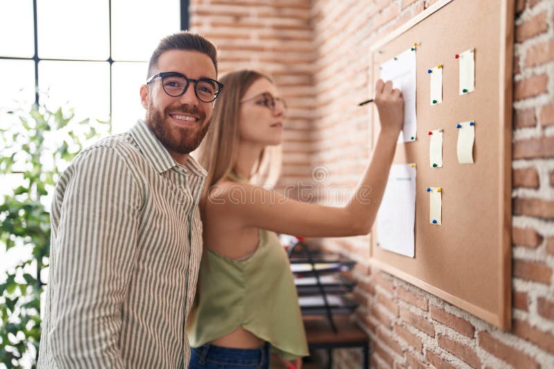 Man and Woman Business Workers Writing on Cork Board at Office Stock ...