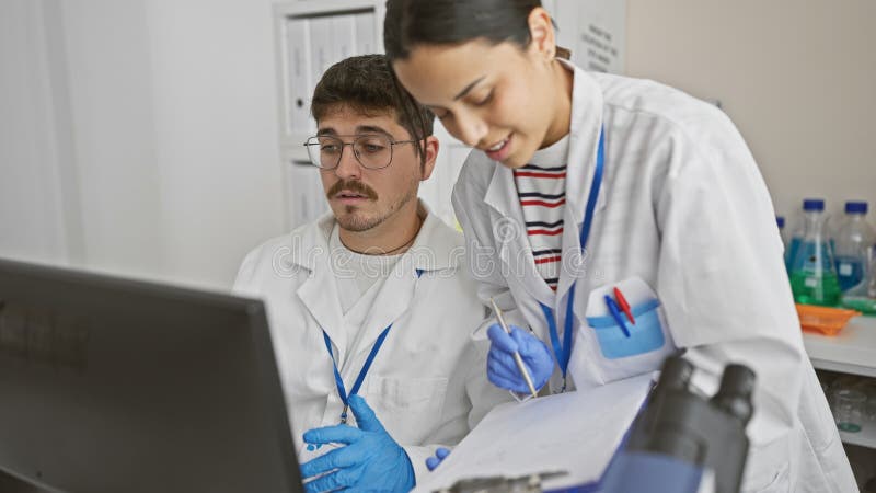 A Man and Woman are Collaborating As Scientists in a Laboratory ...