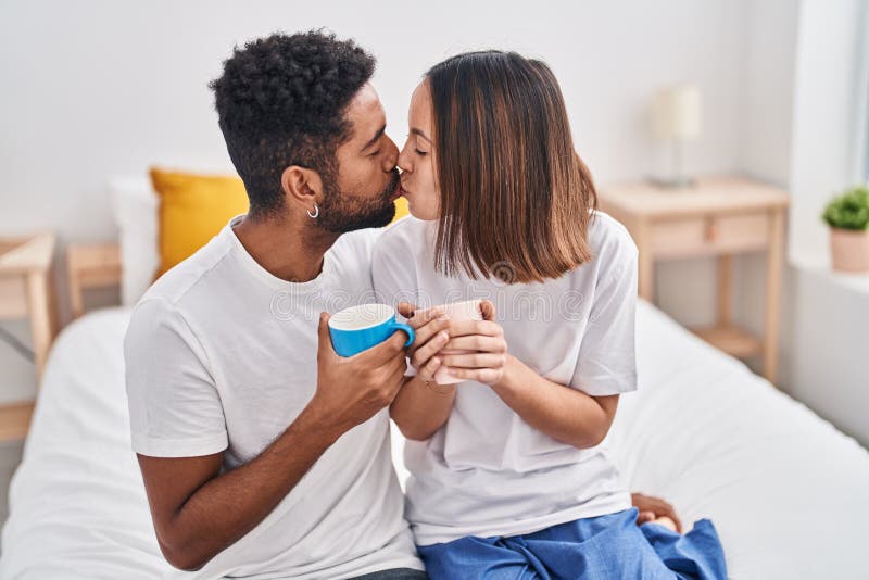 Man And Woman Couple Drinking Coffee Kissing At Bedroom Stock Image