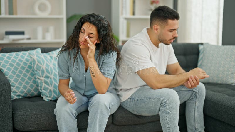 Man And Woman Couple Sitting On Sofa Arguing Stressed At Home Stock
