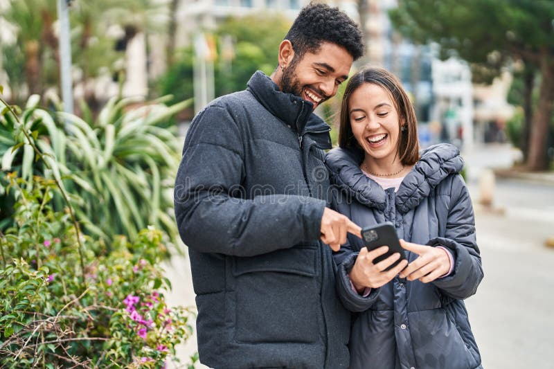 Man and Woman Couple Smiling Confident Using Smartphone at Park Stock ...