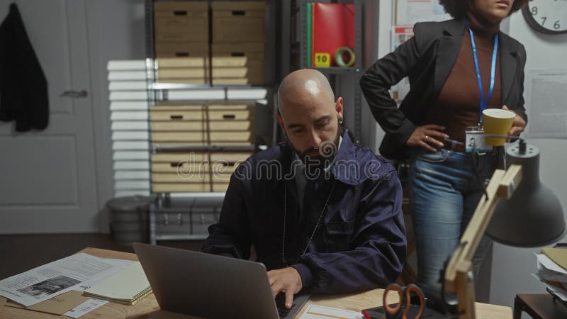 Man and Woman Detectives in Office Analyzing Documents and Using Laptop ...