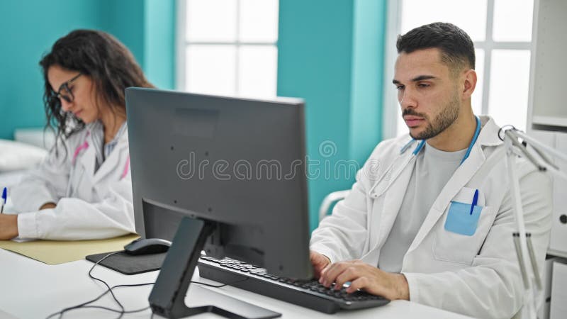 Man and Woman Doctors Using Computer Taking Notes Smiling at the Clinic ...