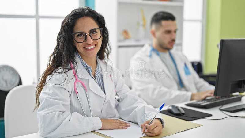 Man and Woman Doctors Using Computer Taking Notes Smiling at the Clinic ...