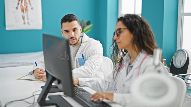 Man and Woman Doctors Using Computer Taking Notes Speaking at the ...