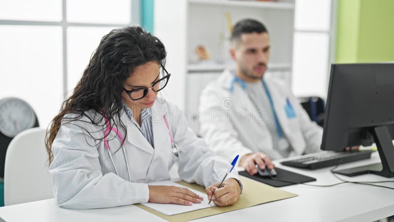 Man and Woman Doctors Using Computer Taking Notes Working at the Clinic ...