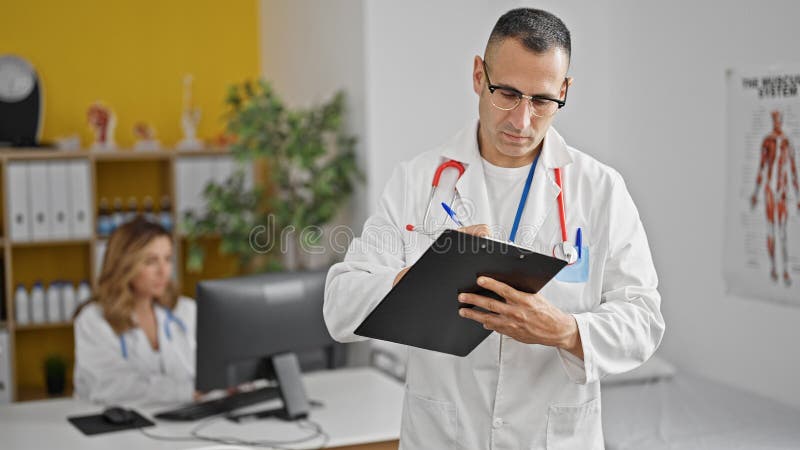 Man and Woman Doctors Writing Medical Report Using Computer Working at ...