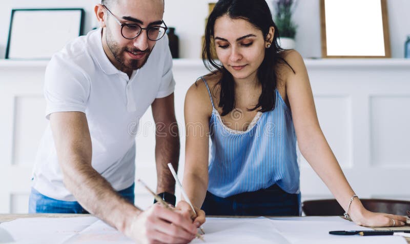 Man and Woman Drawing Together with Pencil on Sheet at Table Stock ...