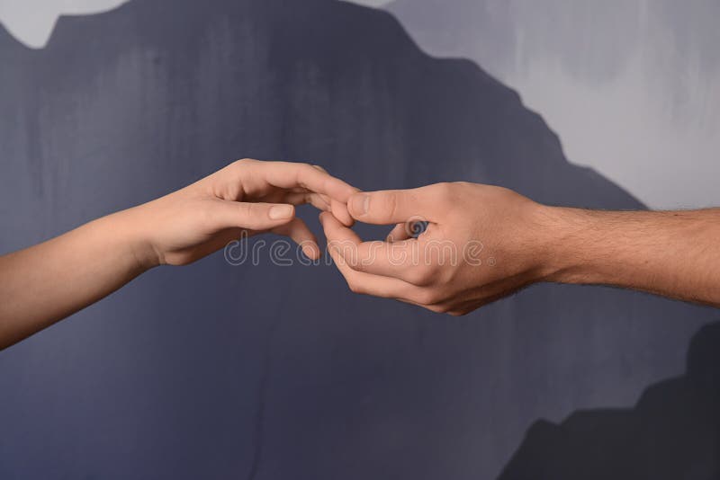 Man and Woman Giving Each Other Hands on Grey Background. Concept of ...