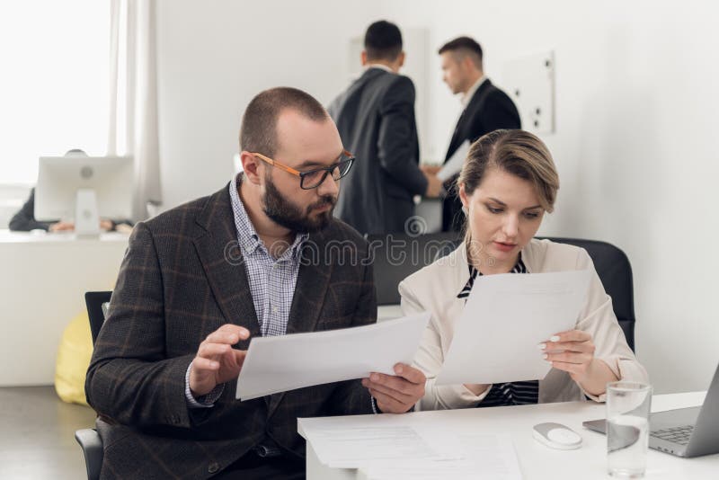 Man and Woman are Holding Documents in Their Hands and Searching ...