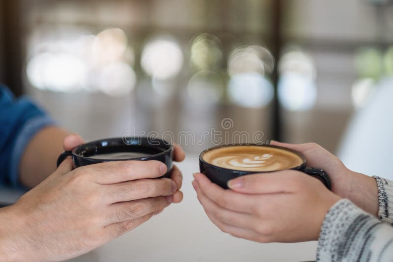 A Man and a Woman Holding Two Coffee Cups Together Stock Photo - Image ...
