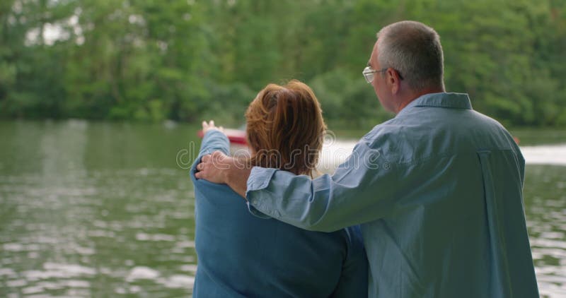 Man and Woman Hugging Each Other by the Water and Watching the Sunset ...