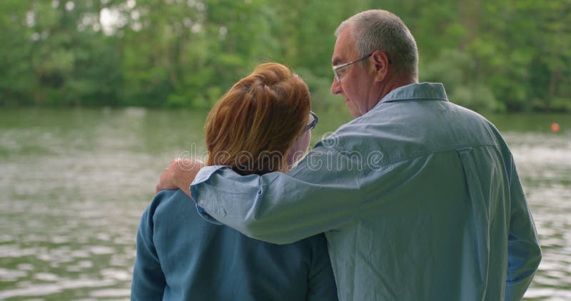 Man and Woman Hugging Each Other by the Water and Watching the Sunset ...