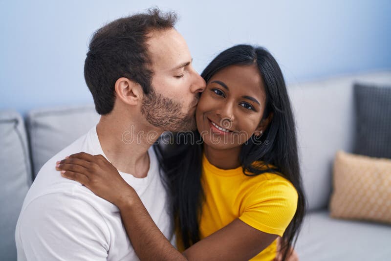 Man And Woman Interracial Couple Hugging Each Other And Kissing At Home