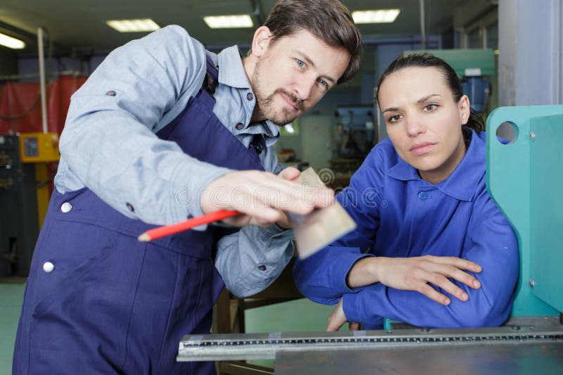 Man and Woman Using Machinery in Industrial Factory Stock Image - Image ...