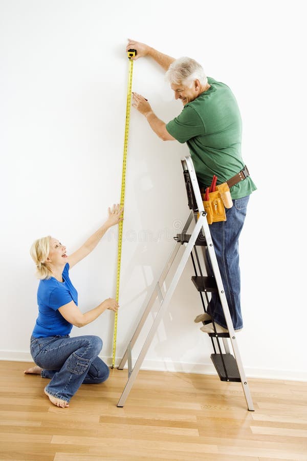 Man and Woman Measuring Wall. Stock Image - Image of male, house: 6153555