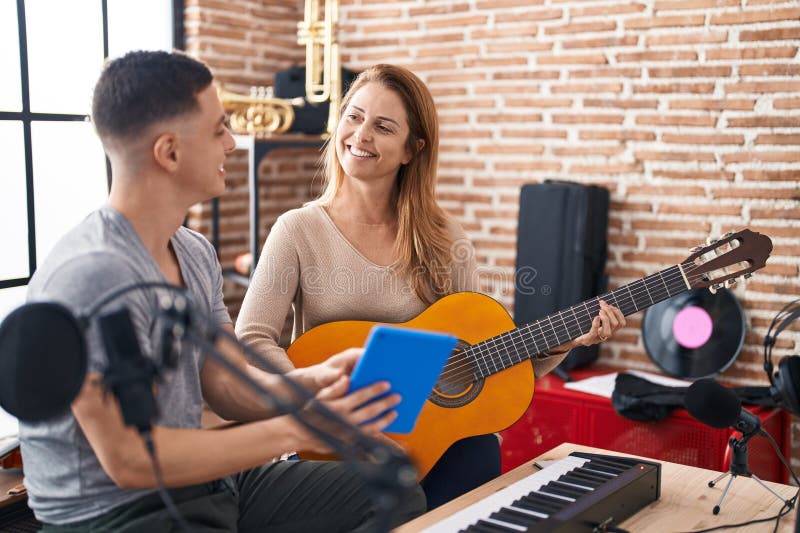 Man and Woman Musicians Having Classic Guitar Lesson Using Touchpad at ...