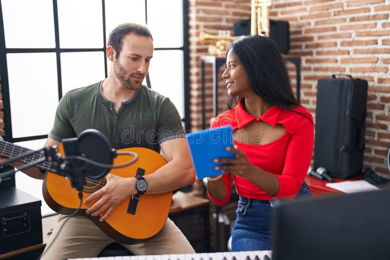 Man and Woman Musicians Playing Classical Guitar Using Touchpad at ...