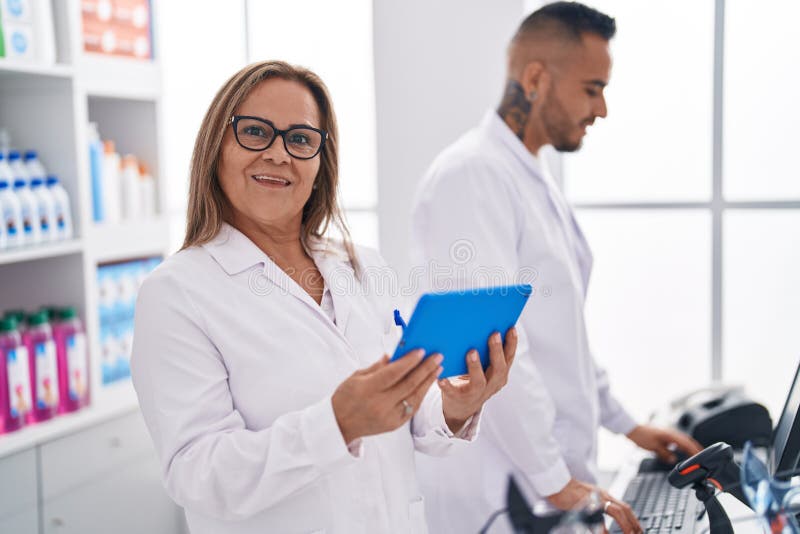 Man and Woman Pharmacist Using Touchpad and Computer at Pharmacy Stock ...