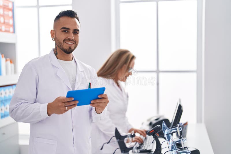 Man and Woman Pharmacist Using Touchpad and Computer at Pharmacy Stock ...