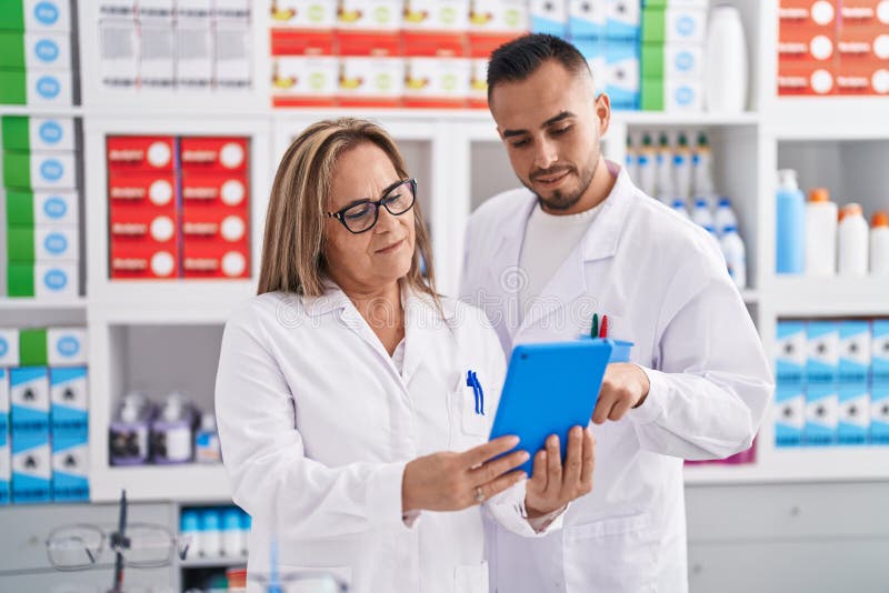 Man and Woman Pharmacist Using Touchpad Working at Pharmacy Stock Photo ...