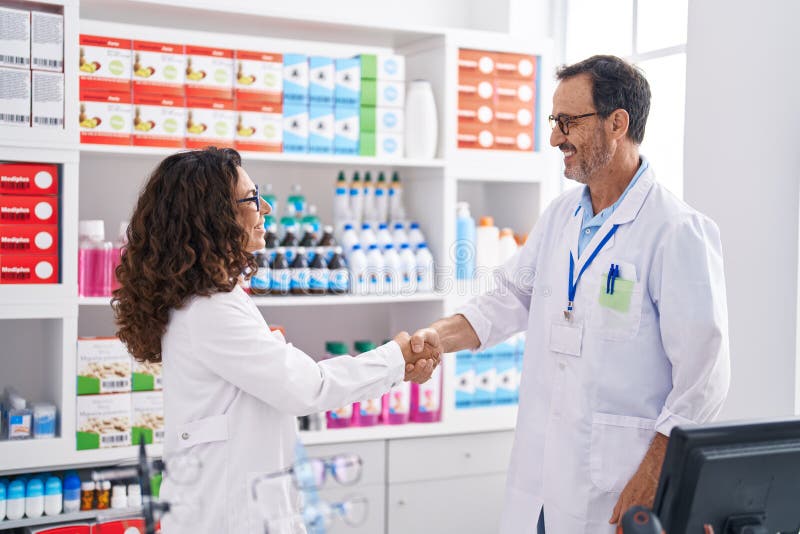 Man and Woman Pharmacists Smiling Confident Shake Hands at Pharmacy ...