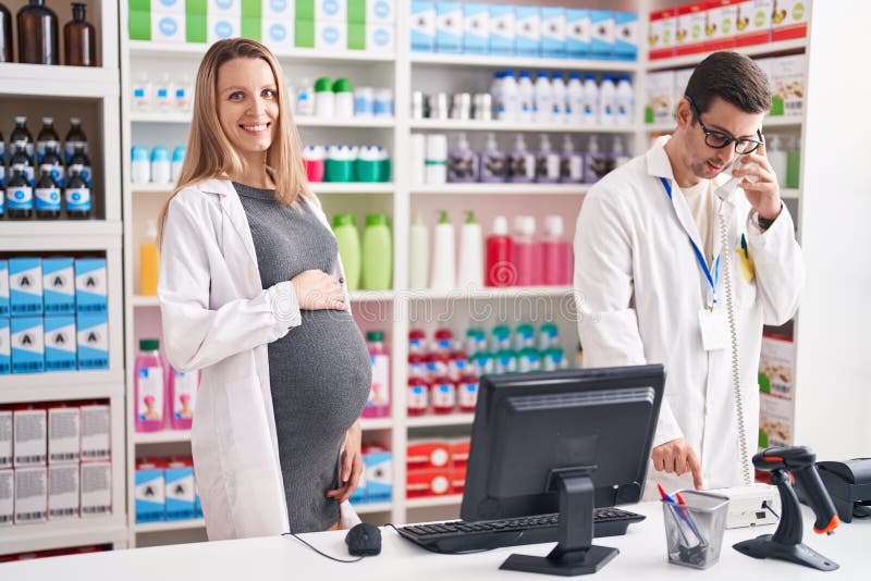 Man and Woman Pharmacists Using Computer Talking on Telephone at ...
