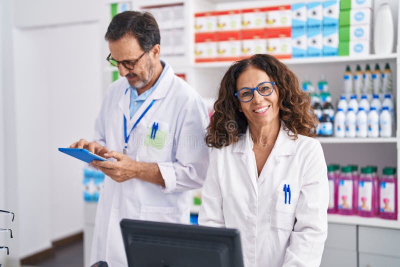 Man and Woman Pharmacists Using Touchpad and Computer at Pharmacy Stock ...