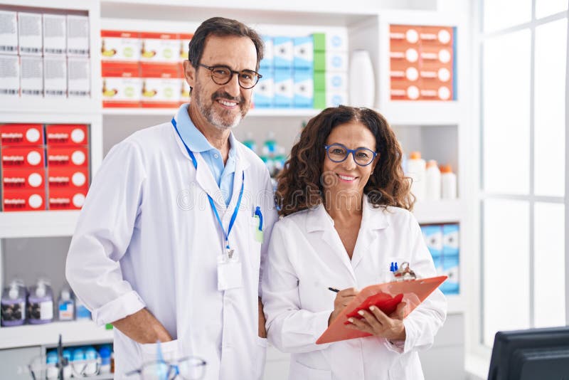 Man and Woman Pharmacists Writing on Document Working at Pharmacy Stock ...