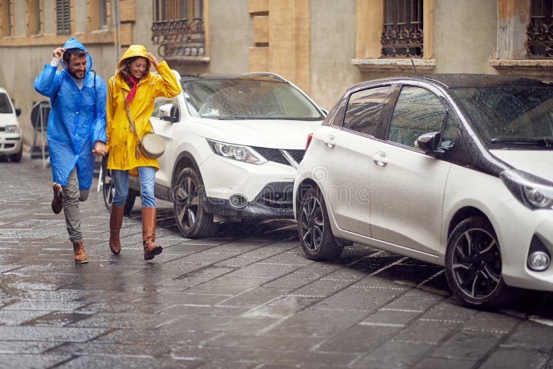 Man and Woman in Raincoats are Running in the Rain Stock Image - Image ...