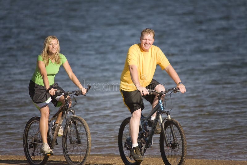 Man and woman riding bikes stock image. Image of peddle - 11481963