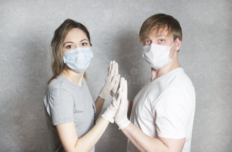 A Man And A Woman In Rubber Gloves And Medical Masks Hold Hands Okved