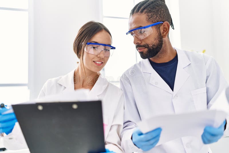 Man and Woman Scientist Partners Reading Documents at Laboratory Stock ...