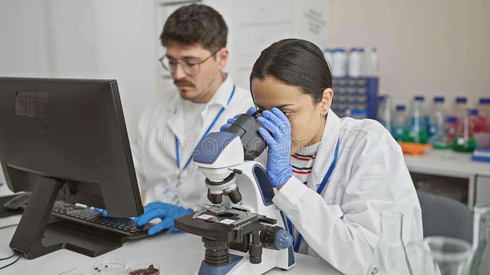 Man and Woman Scientists Collaborate in a Laboratory, with a Microscope ...