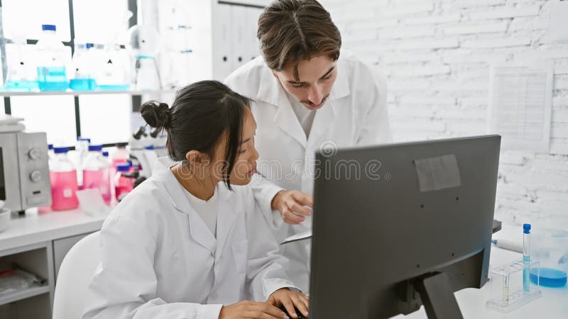 A Man and Woman Scientists Collaborating in a Laboratory Full of ...