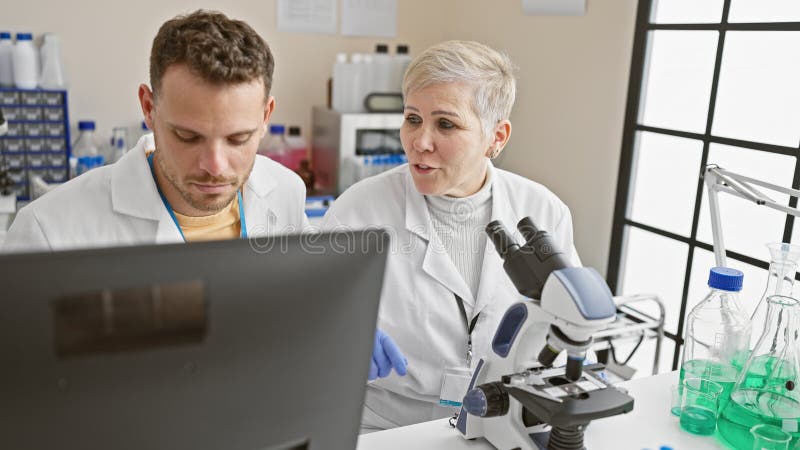 A Man and Woman Scientists in a Lab, Working on Research with ...