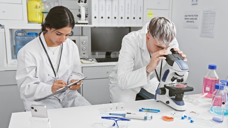 Man and Woman Scientists in Laboratory, Working with Microscope and ...
