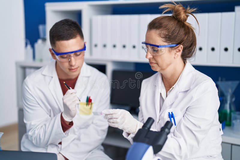 Woman and Man Scientists in Lab Coat Making Notes after Doing Sample ...