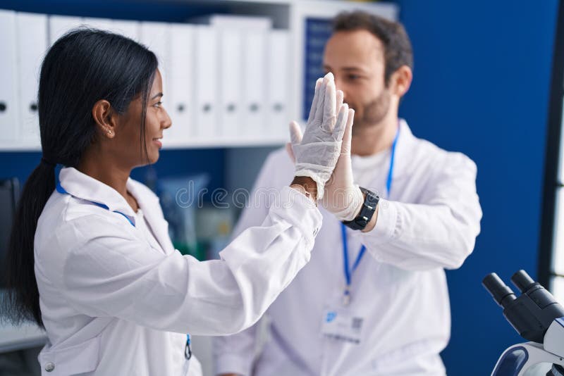 Man and Woman Scientists Smiling Confident High Five at Laboratory ...