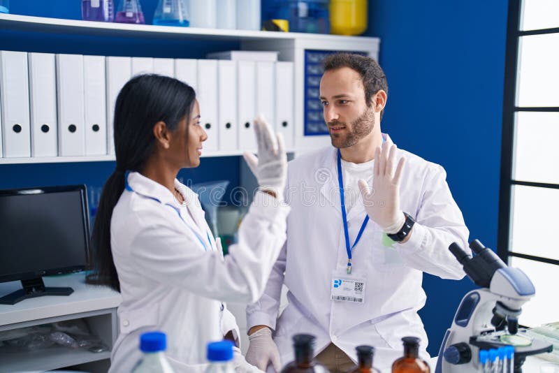 Man and Woman Scientists Smiling Confident High Five at Laboratory ...