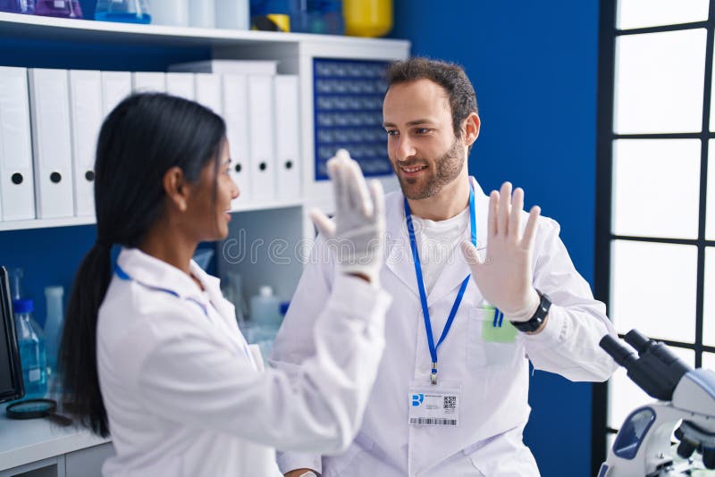 Man and Woman Scientists Smiling Confident High Five at Laboratory ...