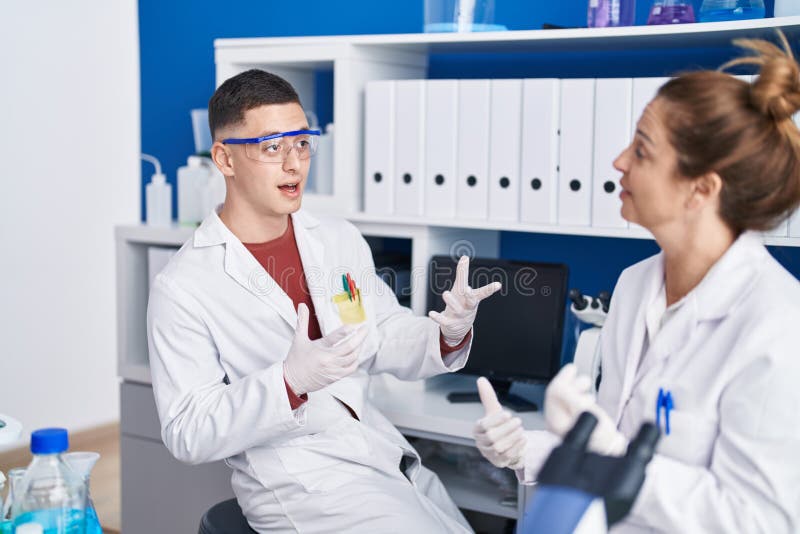 Woman and Man Scientists in Lab Coat Making Notes after Doing Sample ...