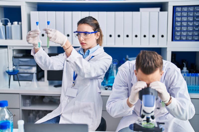 Man and Woman Scientists Using Microscope Holding Test Tubes at ...