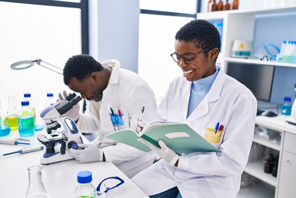 Man and Woman Scientists Using Microscope Writing on Notebook at ...