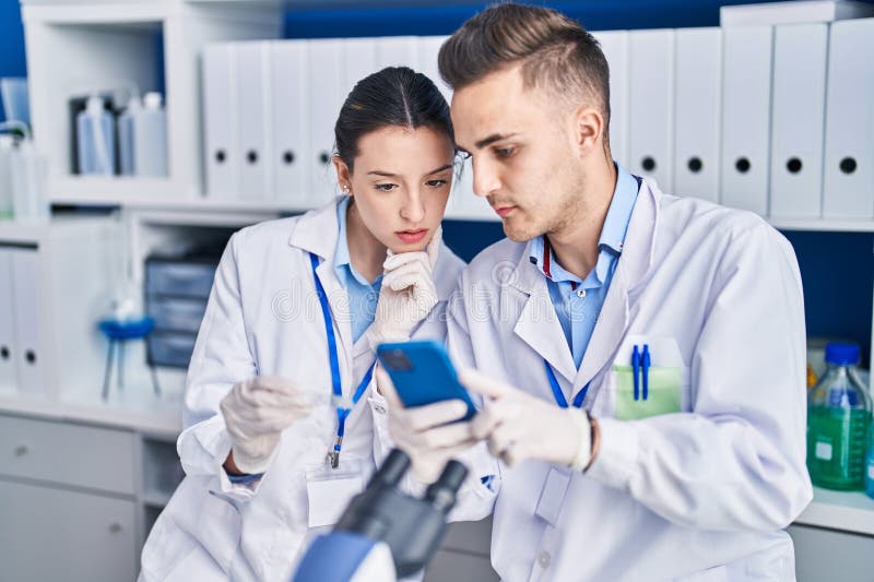 Man and Woman Scientists Using Smartphone Looking Sample at Laboratory ...
