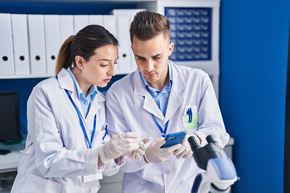 Man and Woman Scientists Using Smartphone Looking Sample at Laboratory ...