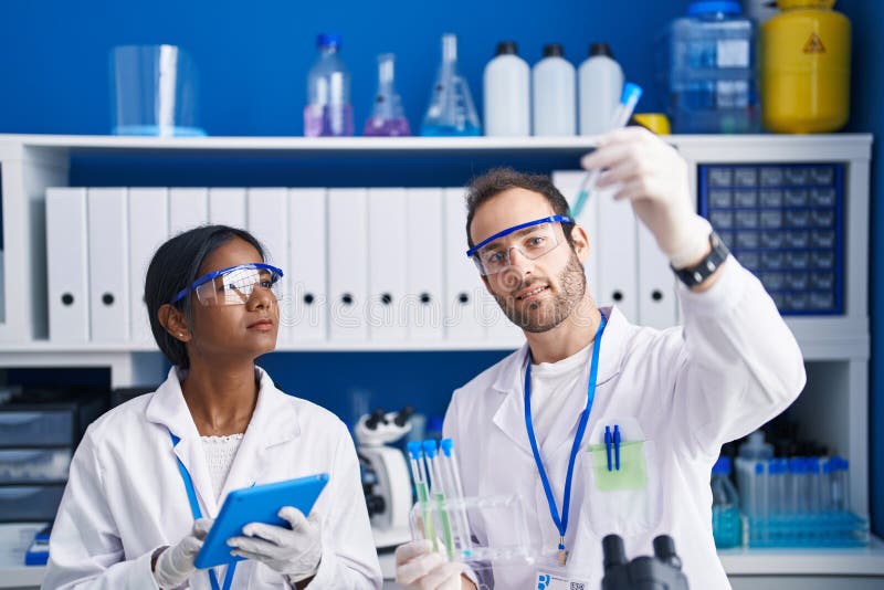 Man and Woman Scientists Using Touchpad Holding Test Tubes at ...