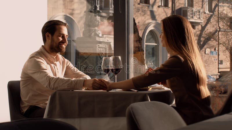 Couple Enjoying a Romantic Dinner at a Cozy Restaurant during Sunset ...