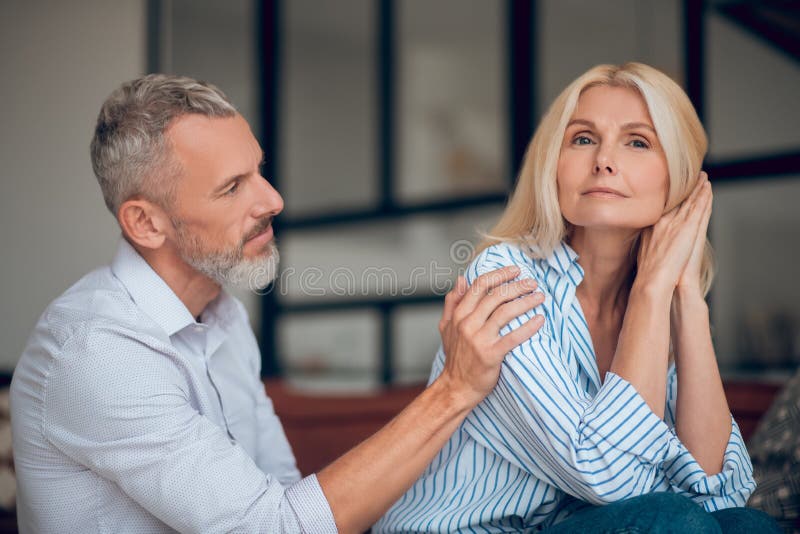 Man And Woman Sitting On The Sofa And Looking Thoughtful Stock Image