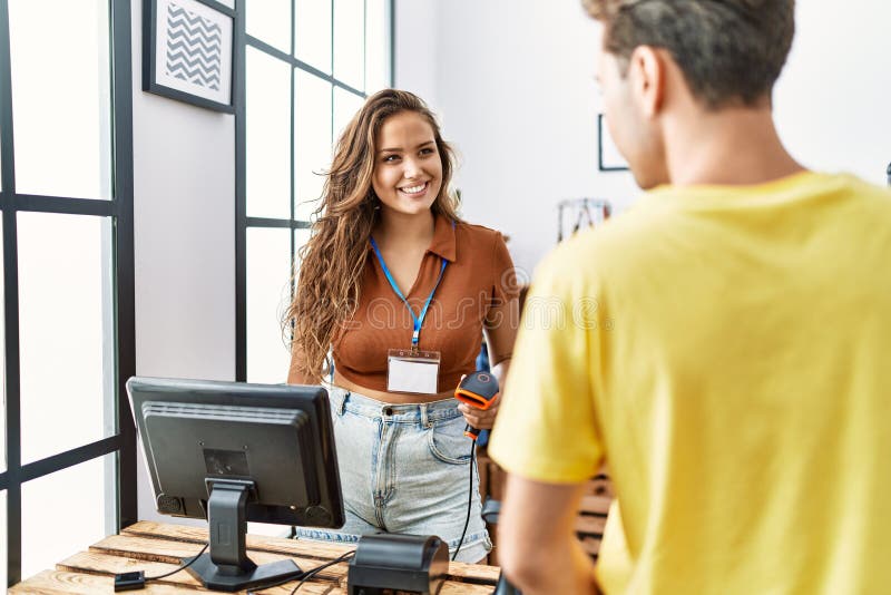 Man and Woman Smiling Confident Using Barcode Reader at Clothing Store ...